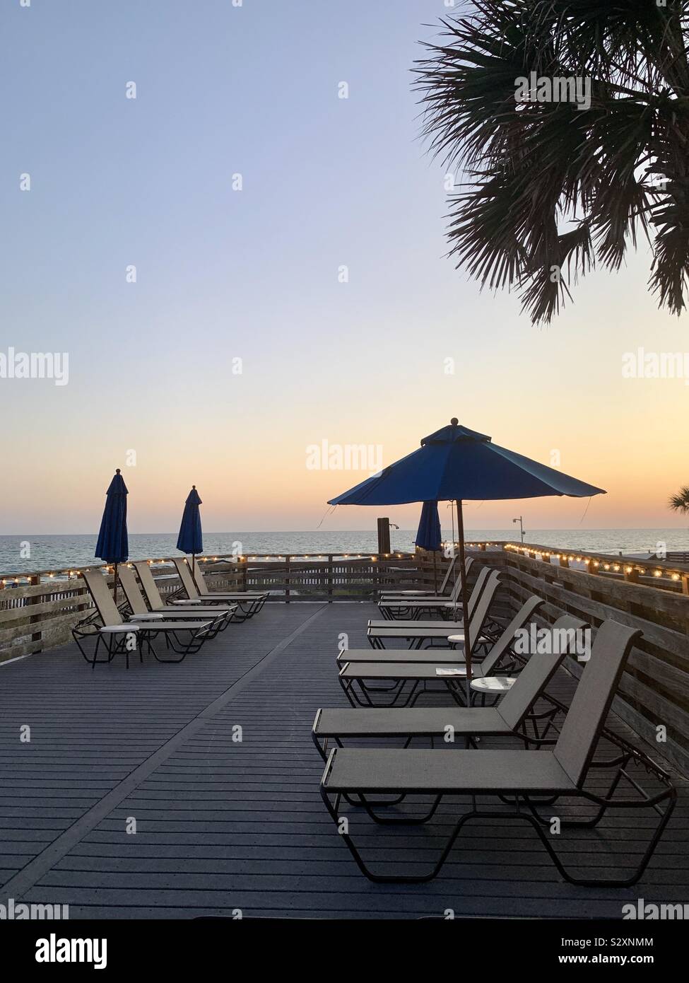 Outdoor seating area on the beach with lounge chairs, umbrellas and ...