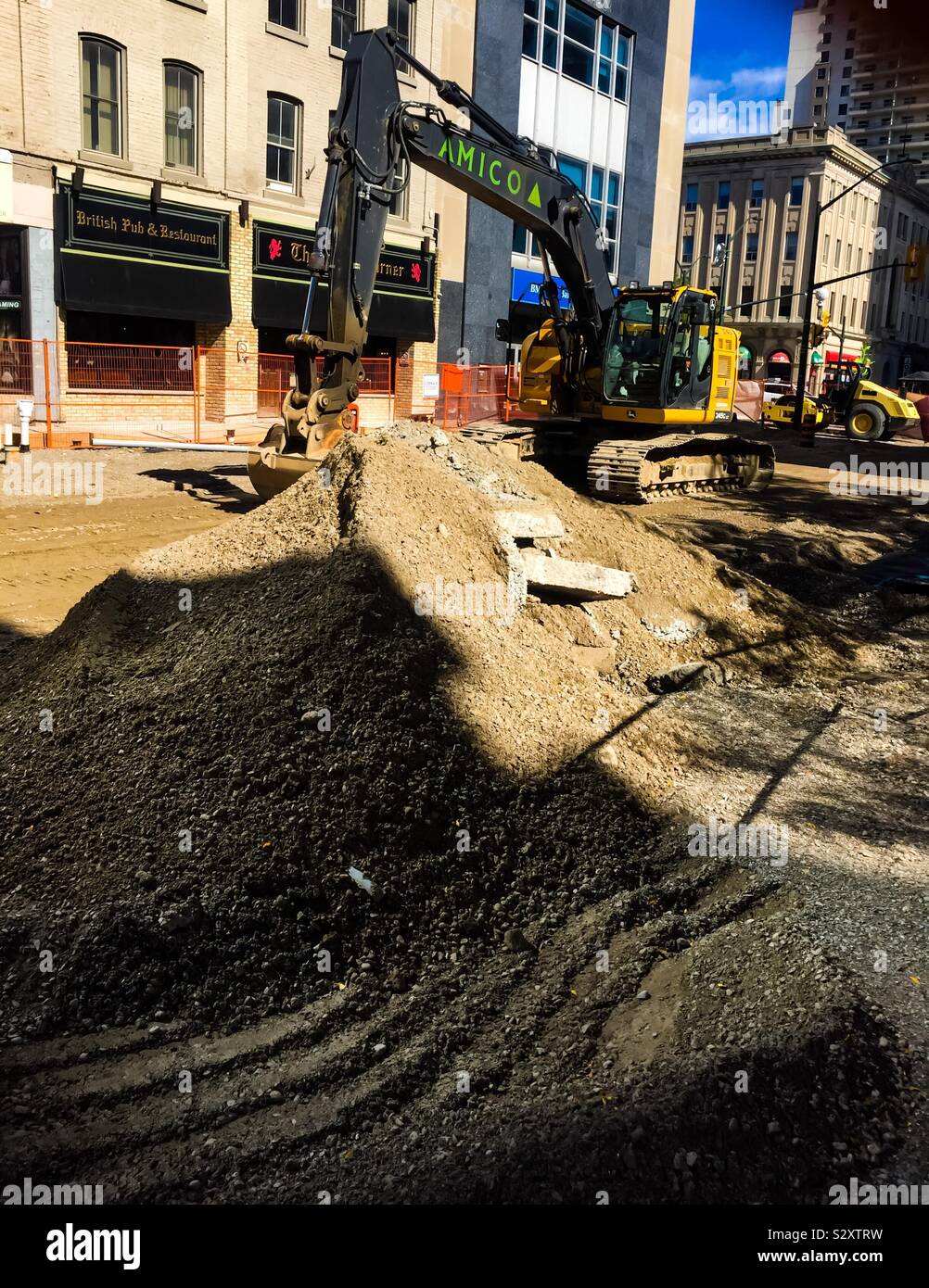 Bulldozer and a pile of rubble on a street Stock Photo - Alamy