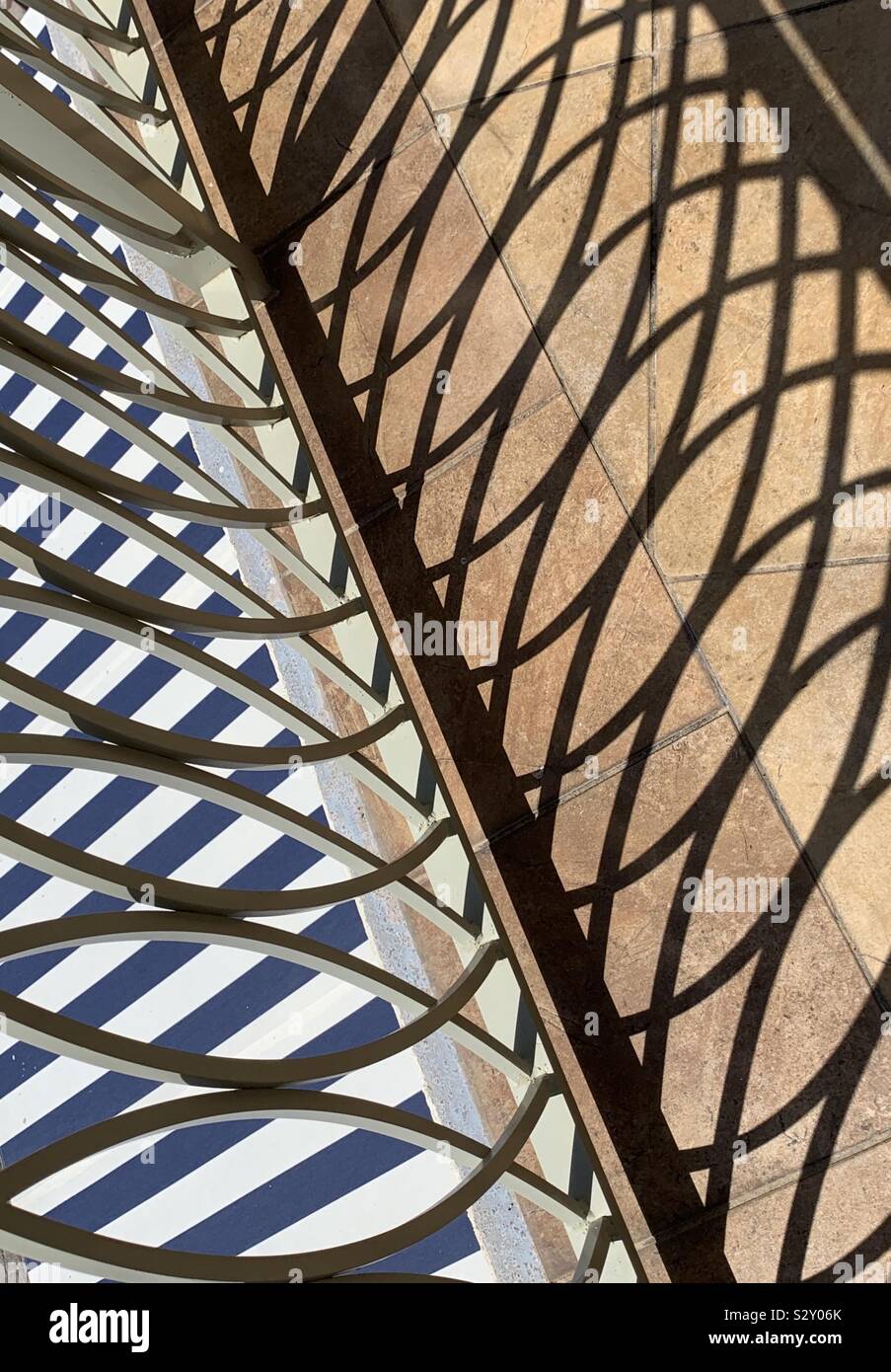Abstract wrought iron fence with shadows on tile Stock Photo - Alamy
