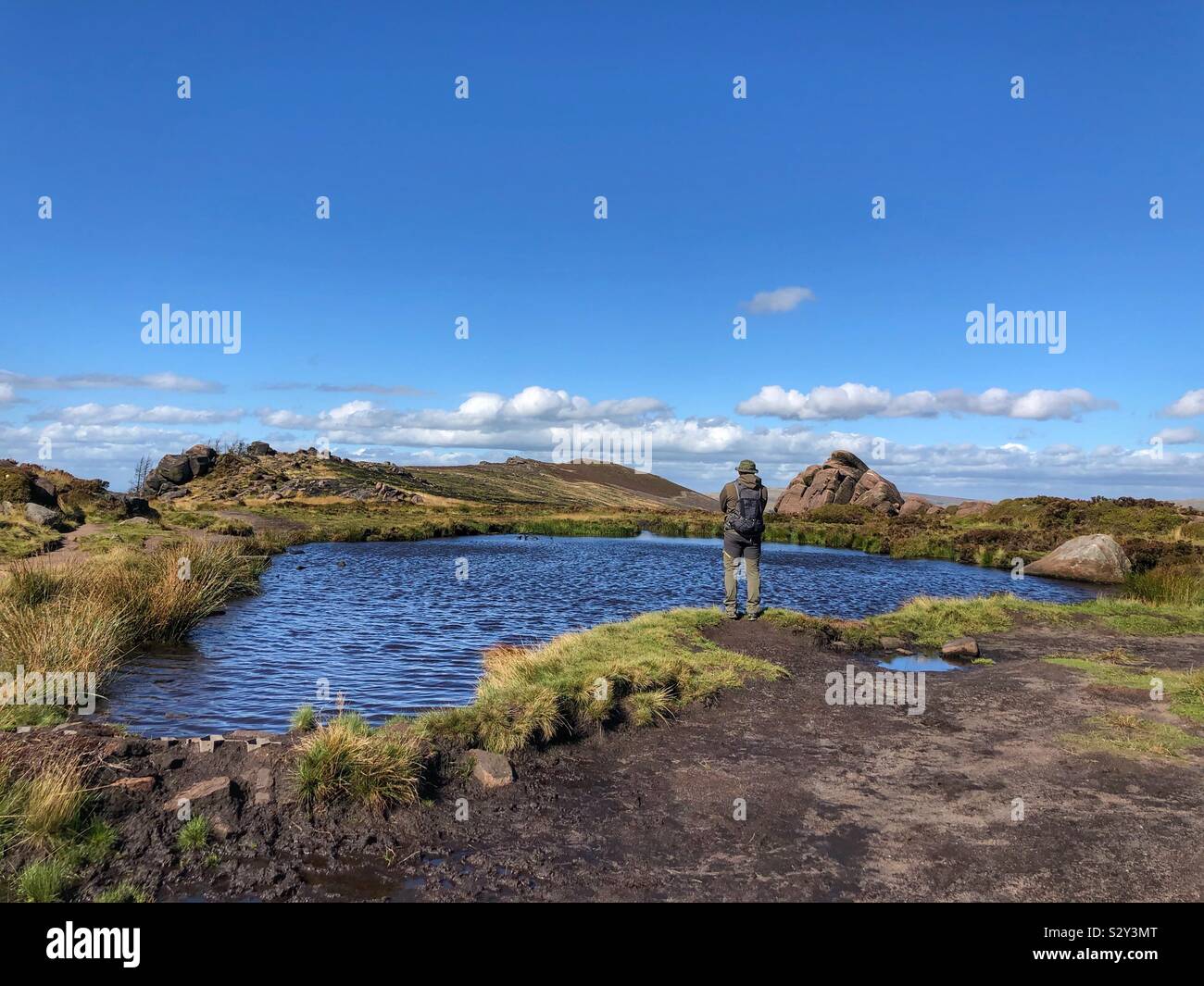 A male hiker standing near the Doxey Pool, The Roaches, Peak District ...