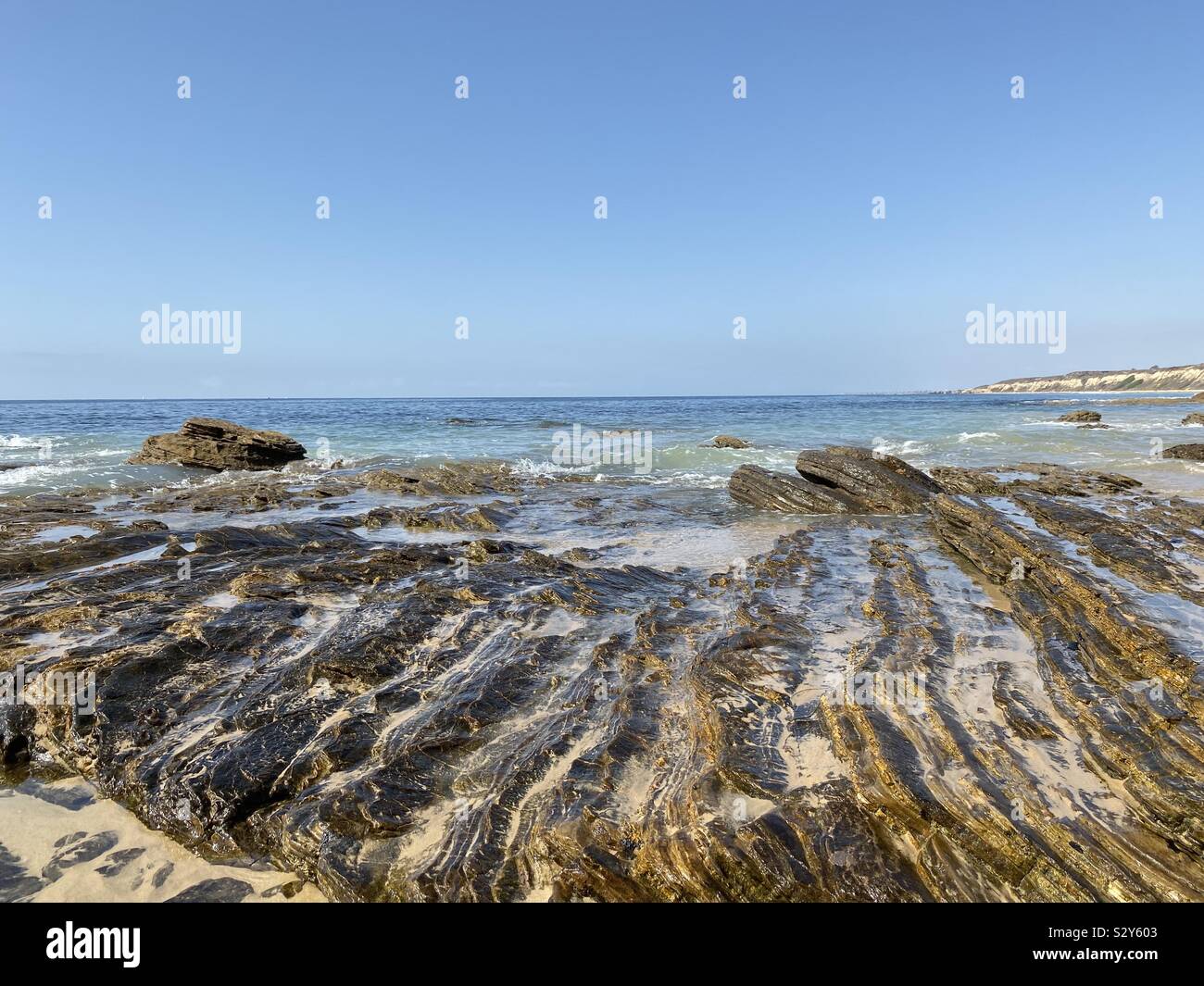 Large rock formations on California beach shoreline with view of the ...