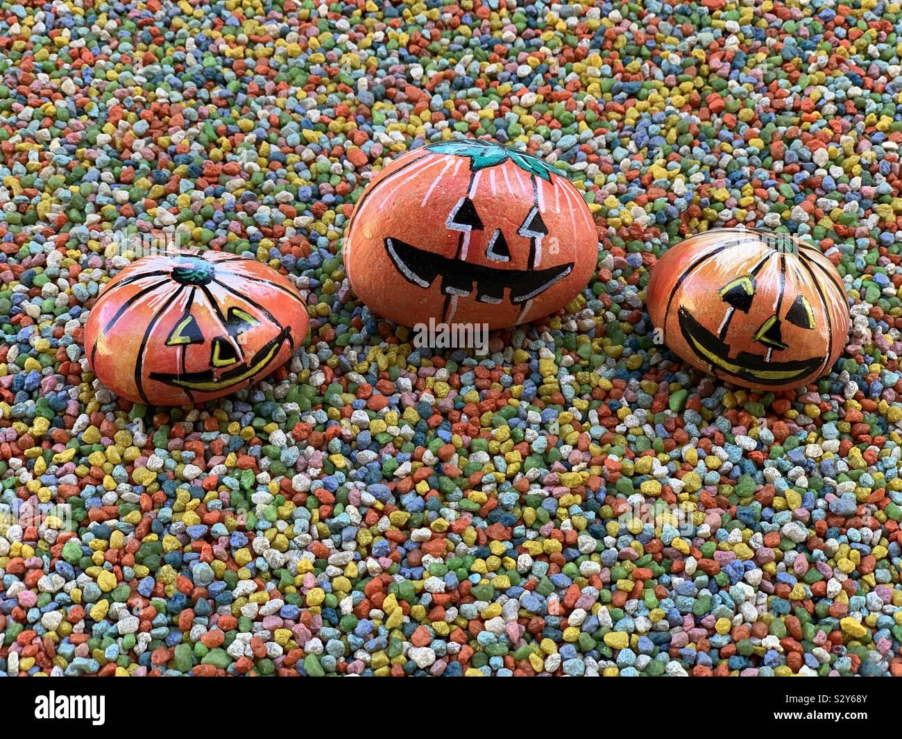 Pumpkins design painted on stones over multicolored gravel Stock Photo ...