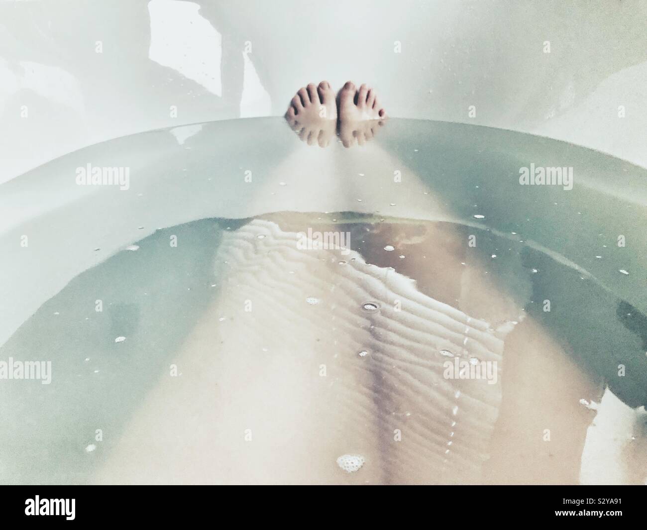 Women’s legs in a bath with toes sticking out Stock Photo - Alamy