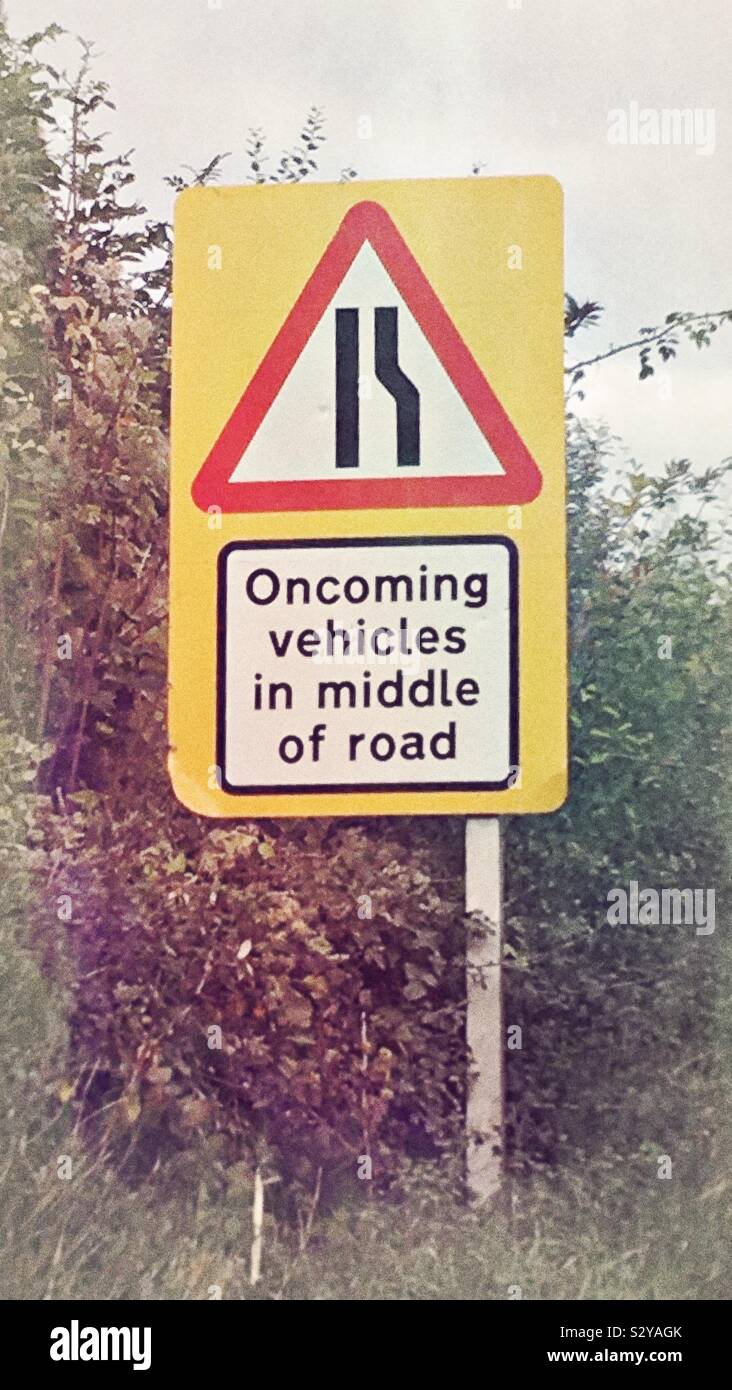 British road sign, with ‘road narrows’ symbol in a red triangle, and ...