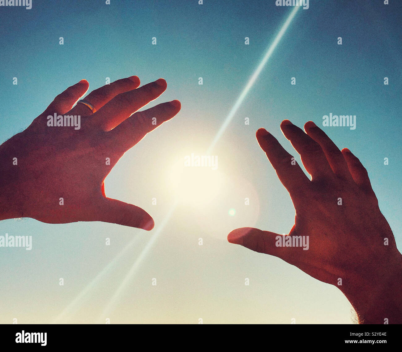 Trying to catch the sun with both hands Stock Photo - Alamy