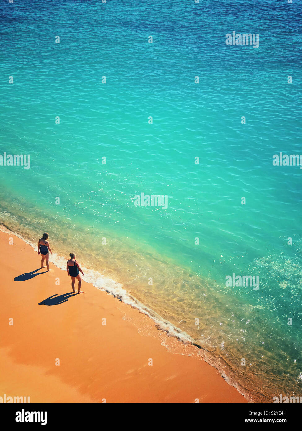 Two bathers about to go into the sea on the Algarve coast, Portugal ...