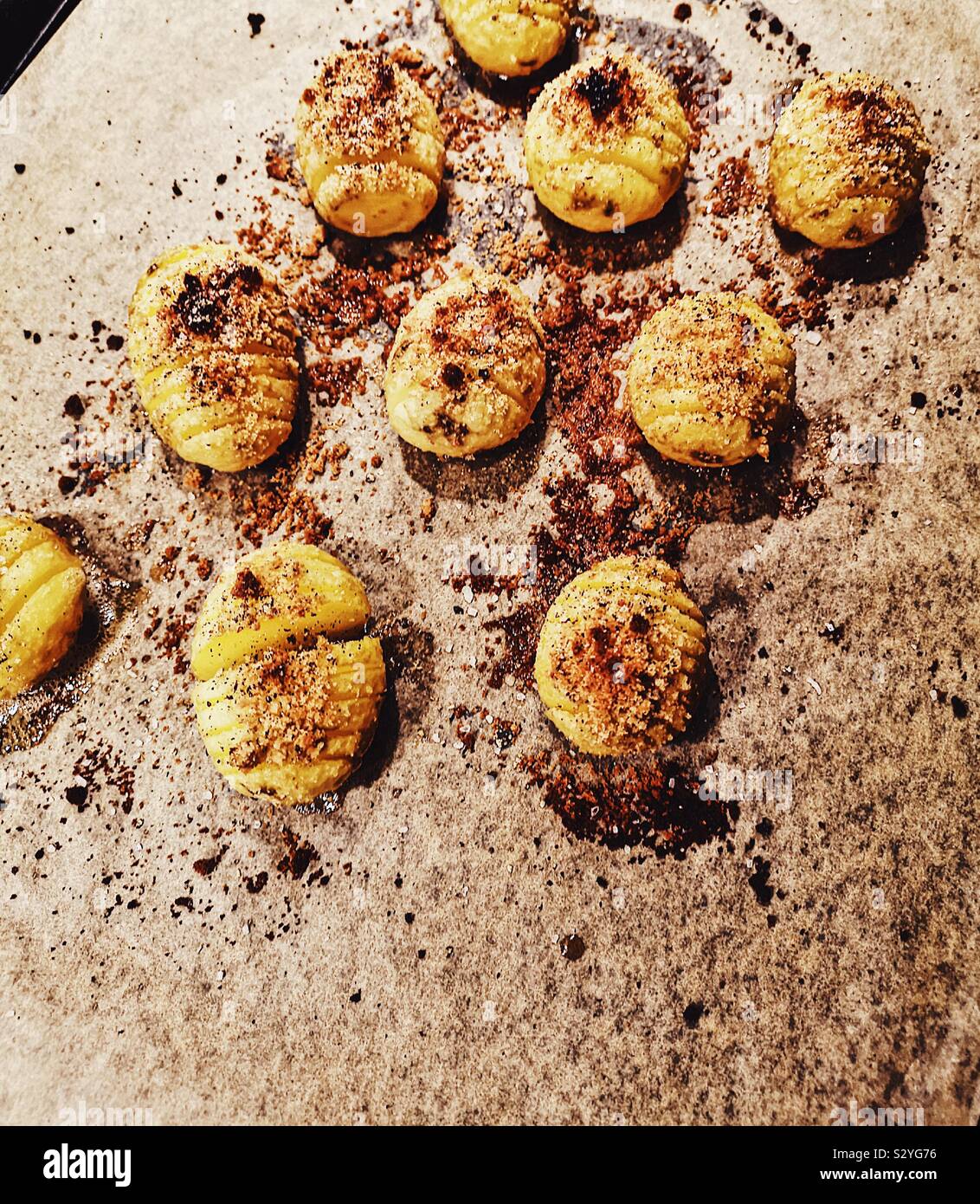 Hasselback potatoes on baking tray. Swedish traditional dish where ...