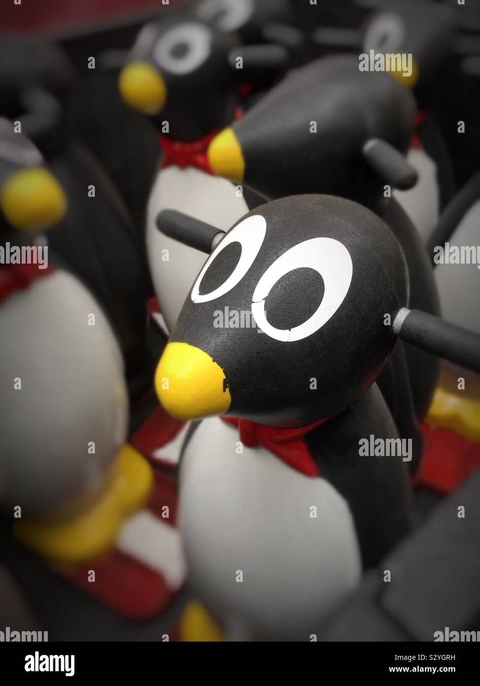 Penguin shaped ice skate helpers in a storage bin next to an ice rink ...