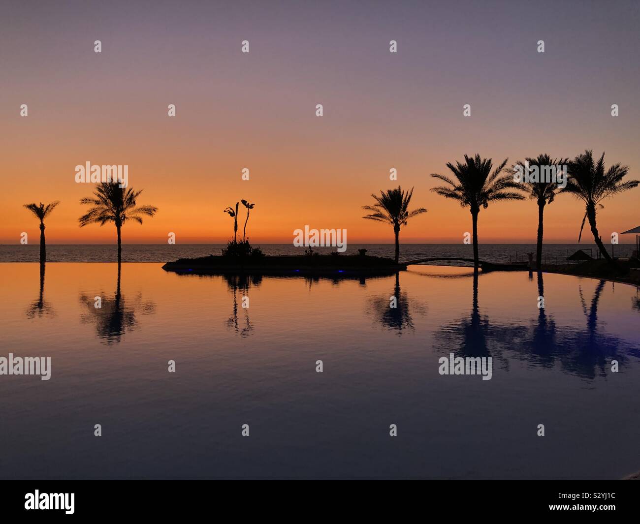 Sunset on infinity pool Stock Photo - Alamy