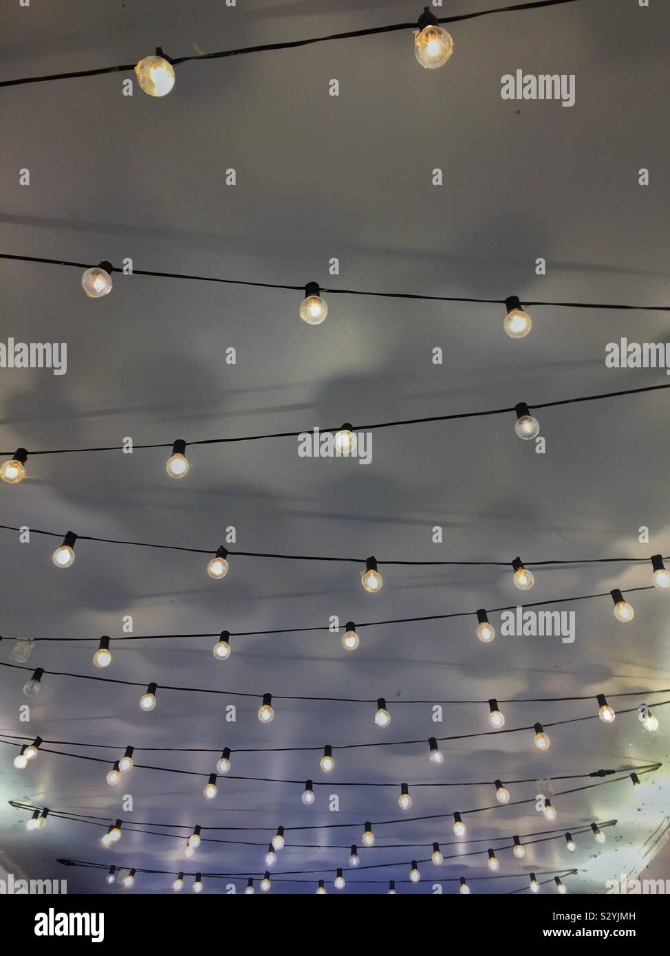 Lights strung across a ceiling Stock Photo - Alamy