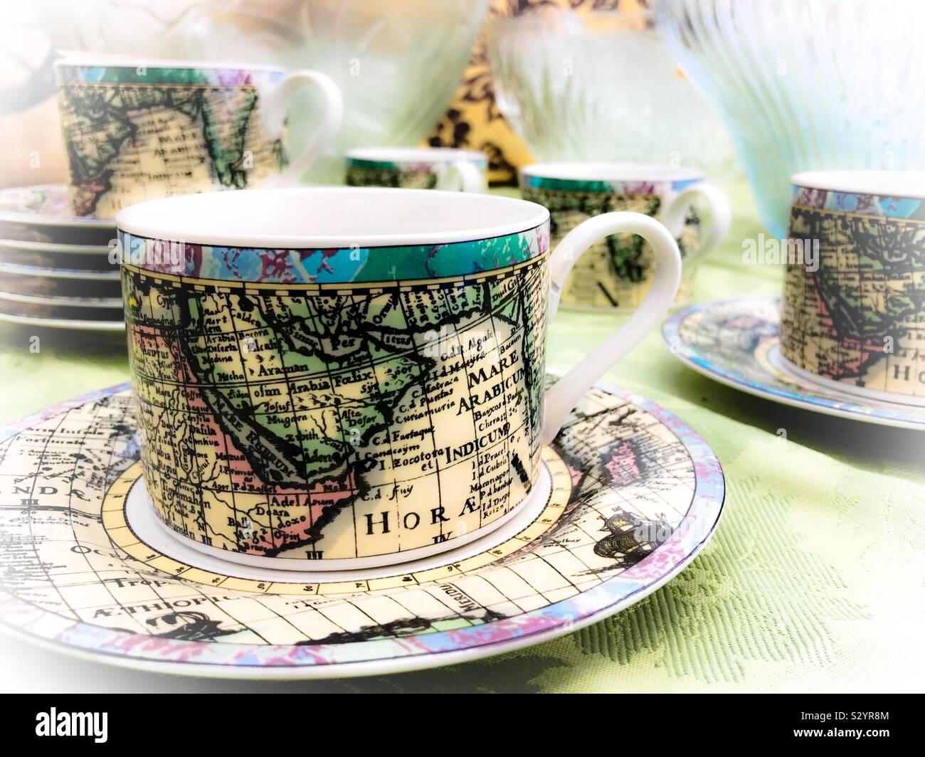 Softly vignetted photo of tea set printed with colorful world map on ...