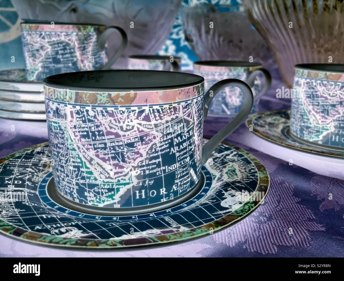 Inverted photo of teacups and saucers printed with world map design on ...