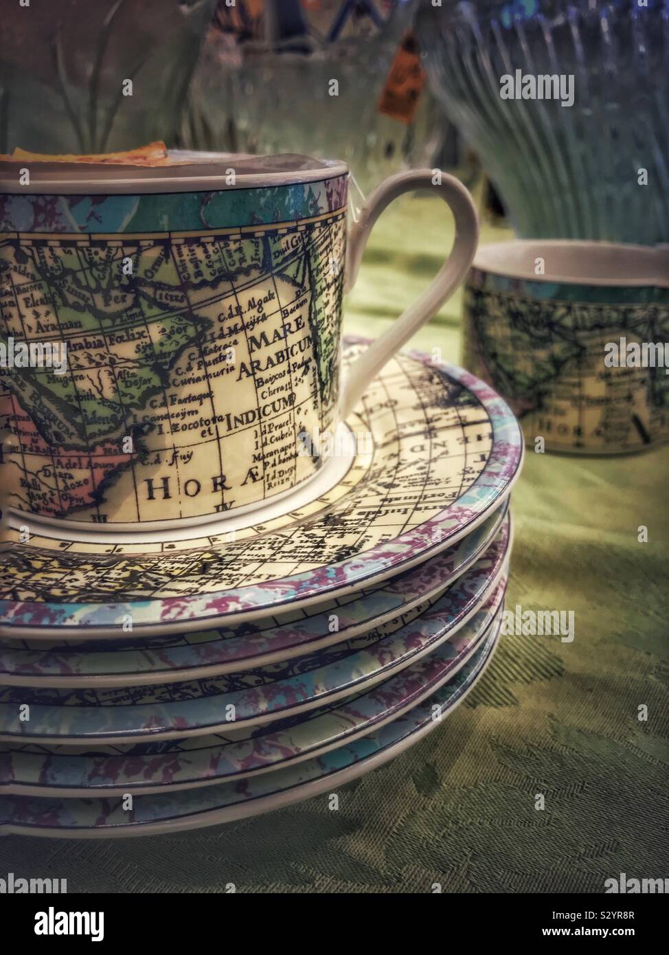 Stack of saucers and teacups printed with world map design on display ...