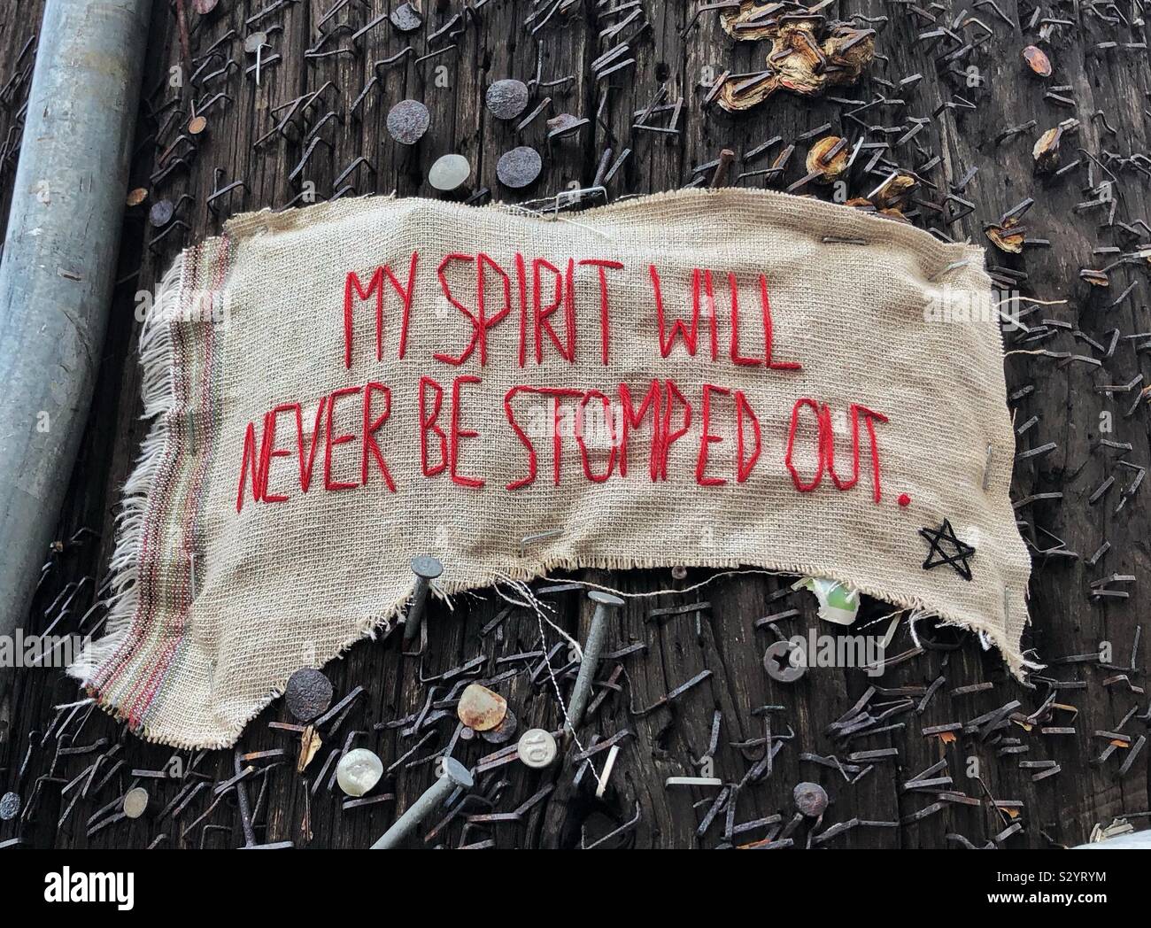 Embroidered sign affixed to telephone pole reading “My Spirit Will ...