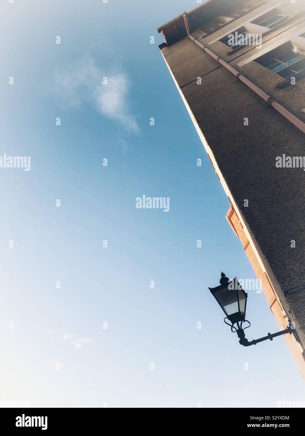 Ornate lamp on side of tall building Stock Photo - Alamy