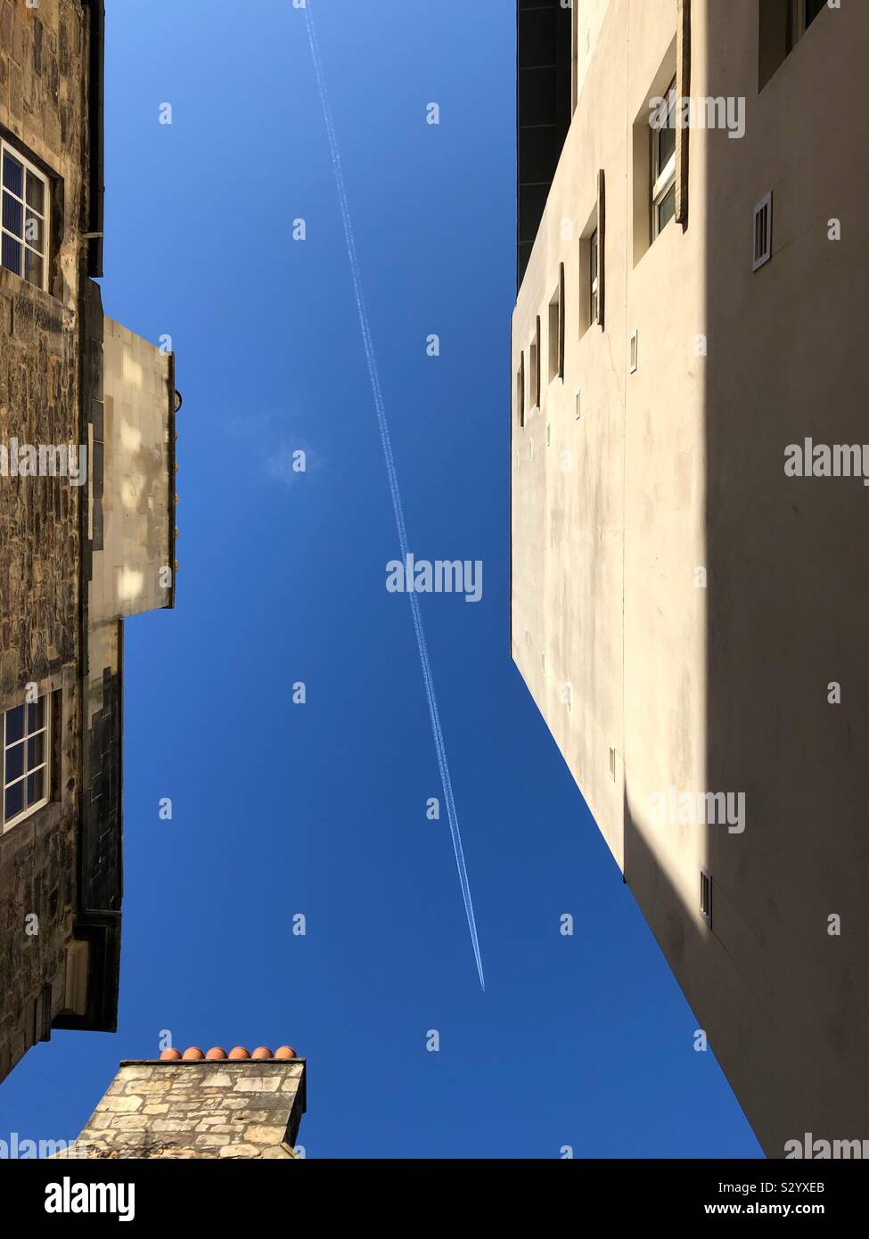 Looking up at a jet overhead between urban buildings Stock Photo - Alamy
