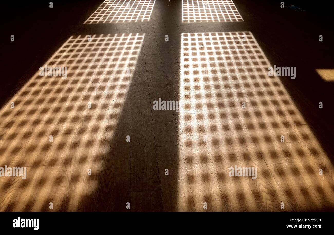 Sunlight through windows casts cross shadow pattern Stock Photo - Alamy