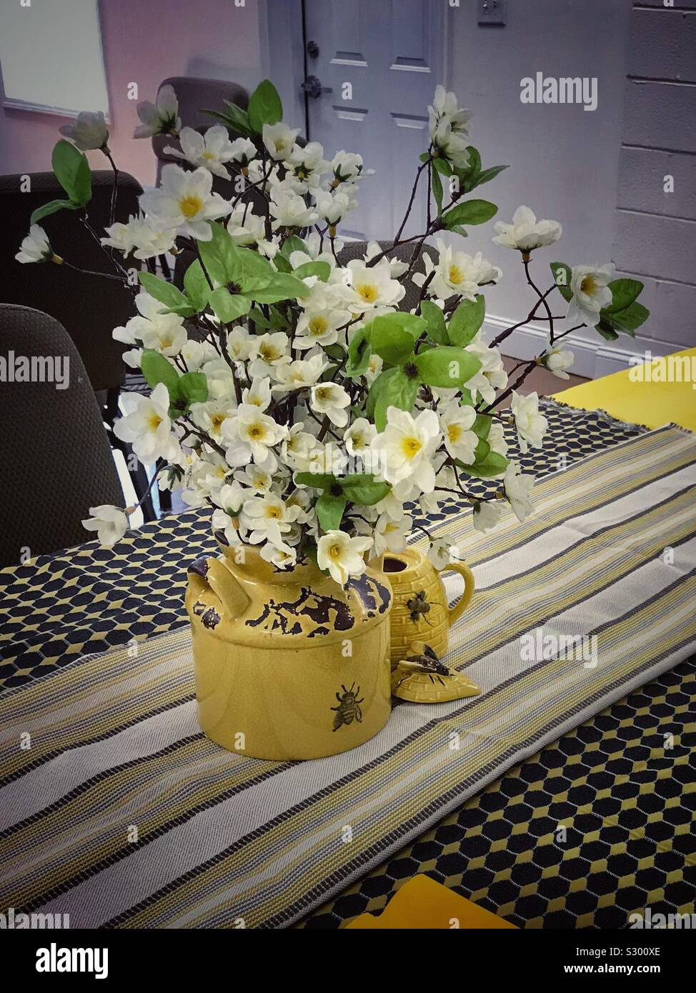 White silk flower arrangement in bee themed yellow ware honeypot Stock ...