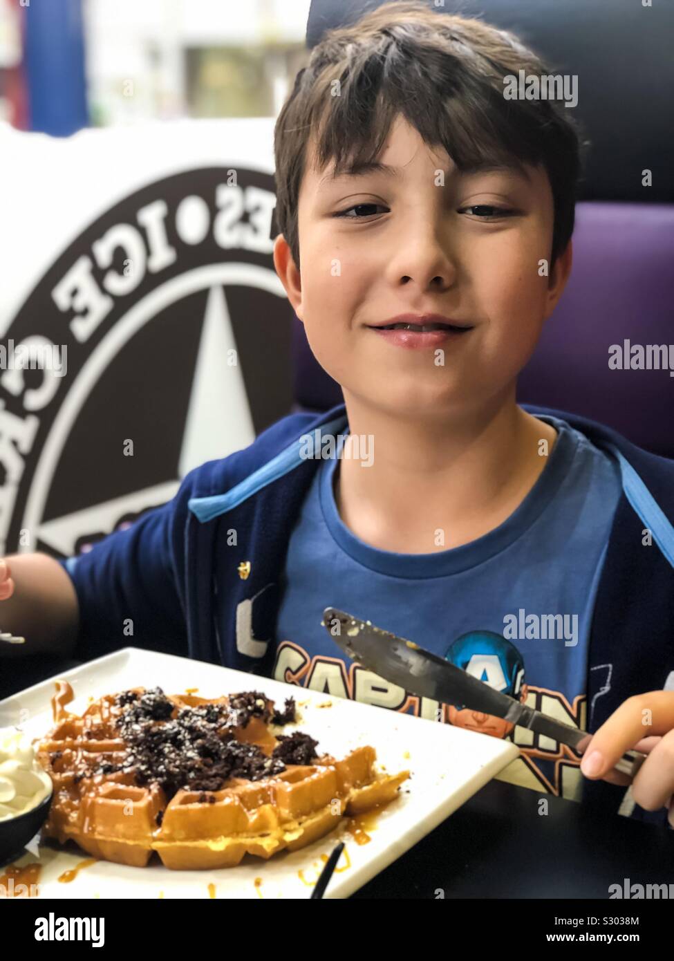 A boy eating a waffle in a cafe Stock Photo - Alamy