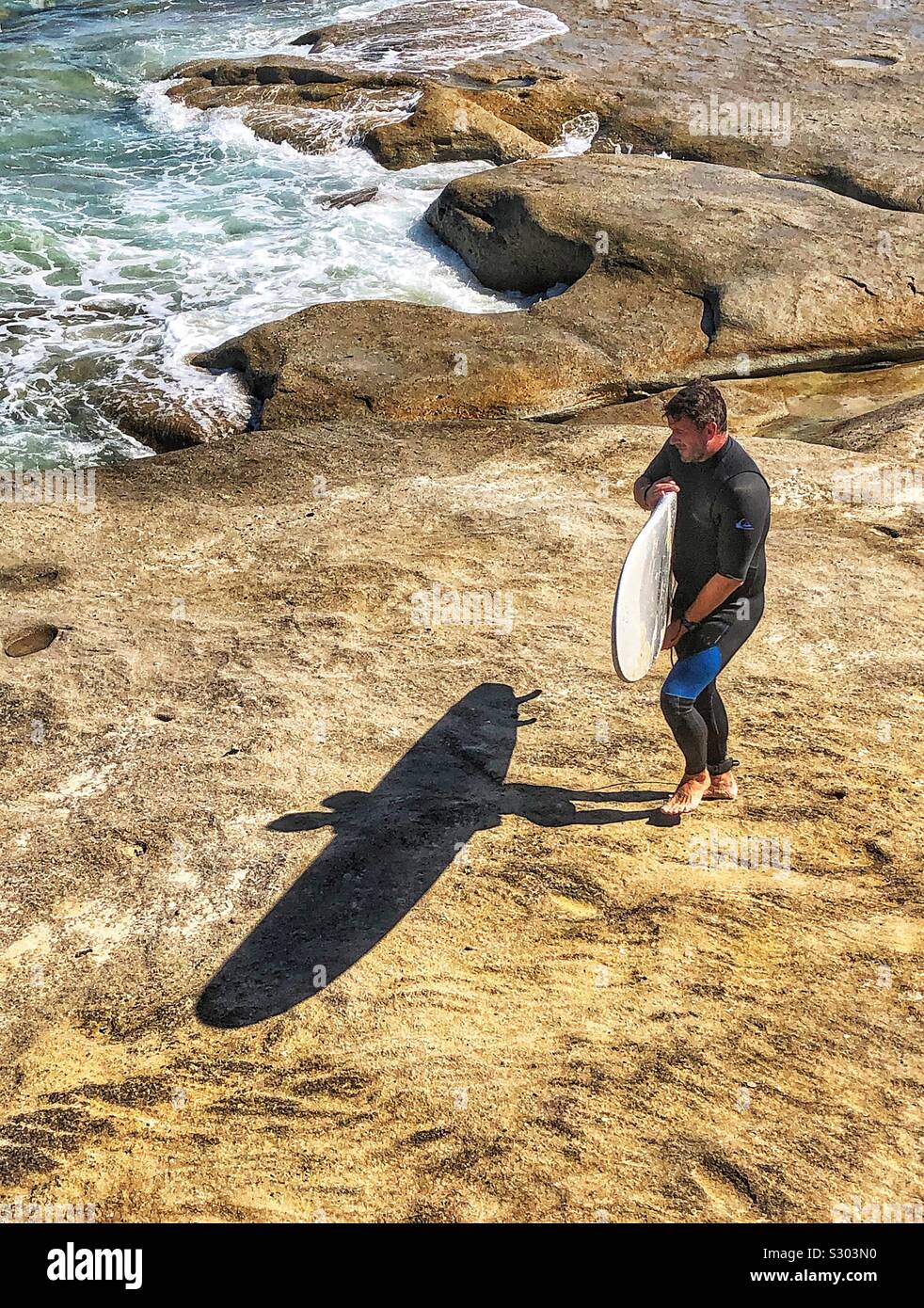 Surfboarder on rocks Australian Lifestyle Stock Photo - Alamy