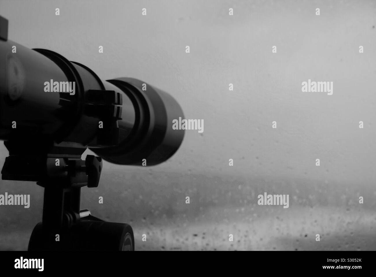 Telescope looking out of window on a rainy day Stock Photo - Alamy