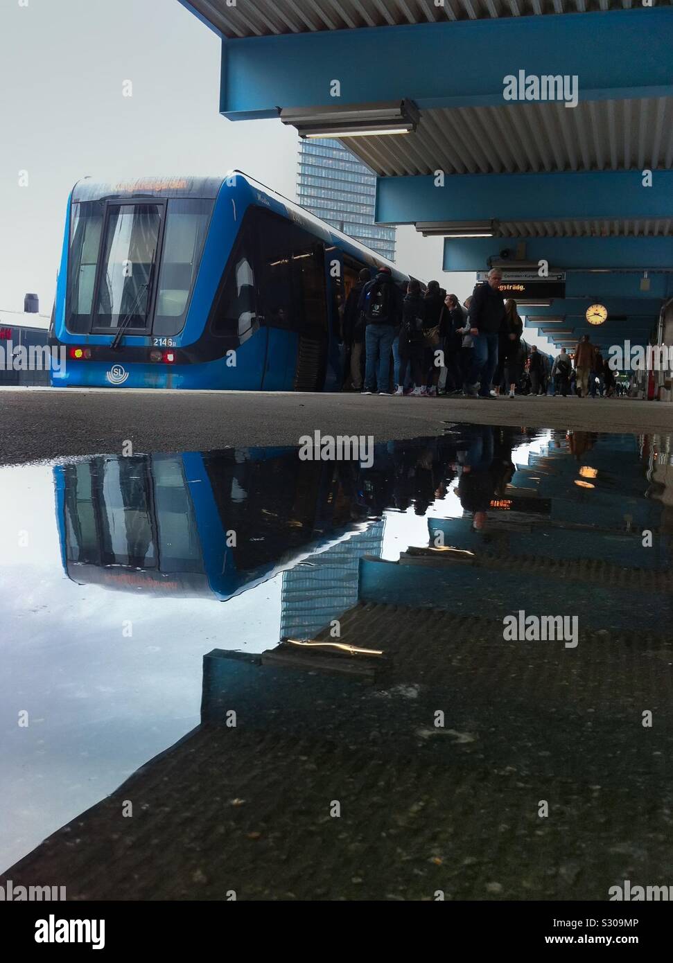Metro subway train and silhouetted passengers reflected on a pool of ...