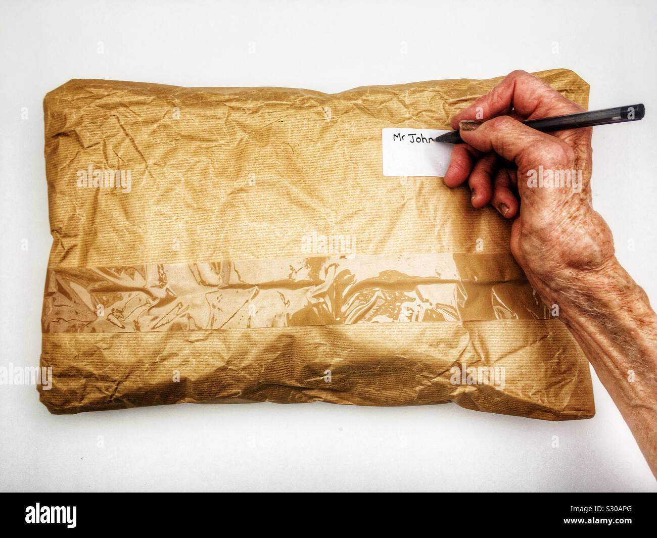 Addressing a brown paper parcel Stock Photo - Alamy