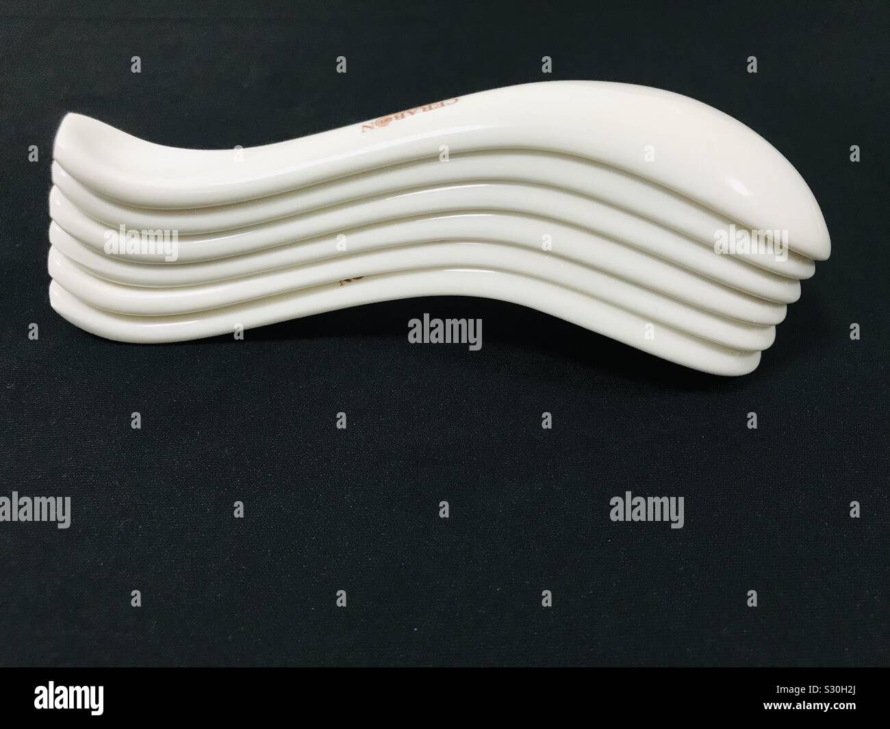 Stack of chinese porcelain spoon facing upside down on black background ...