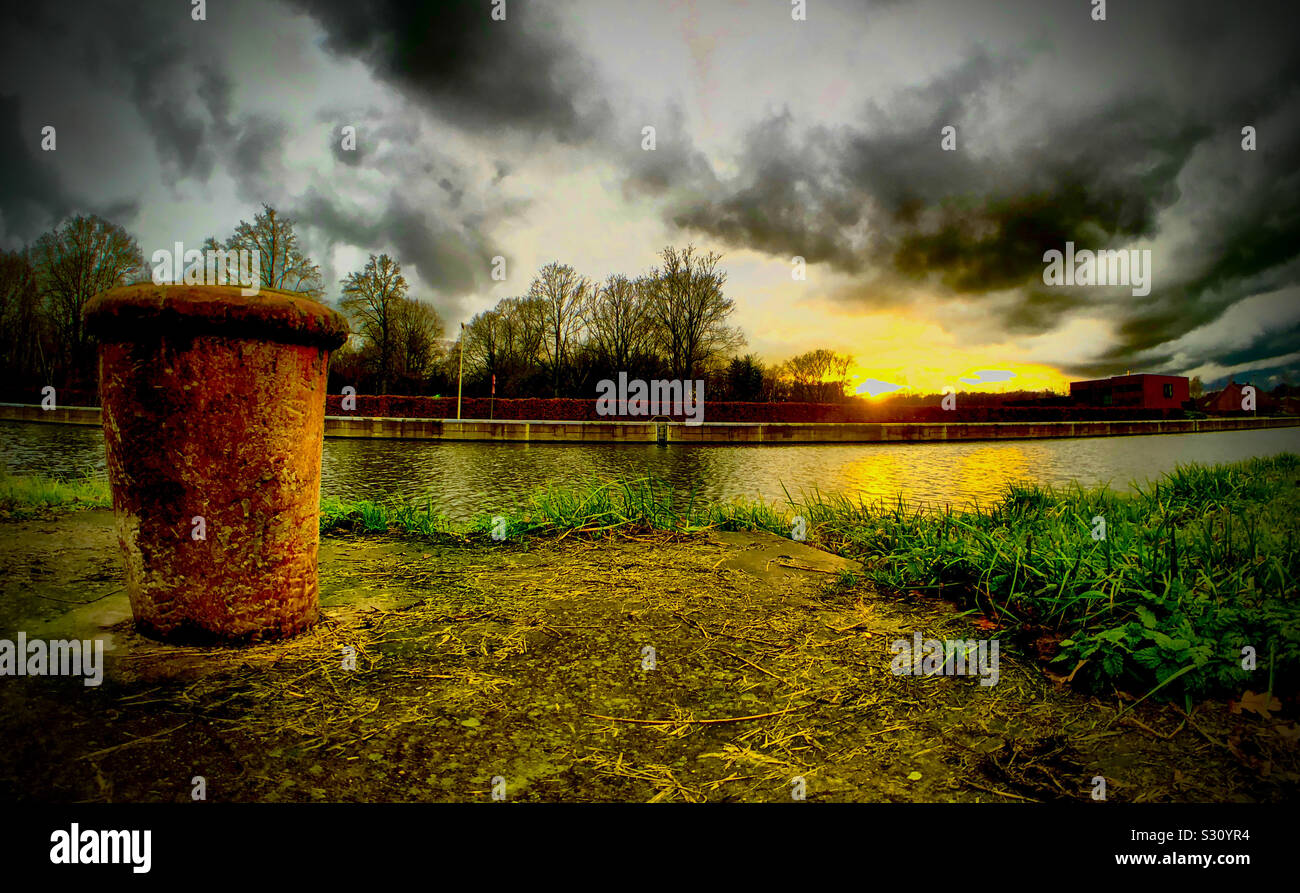 Rusty boulder on the woodland riverside under a stormy sunset sky Stock ...