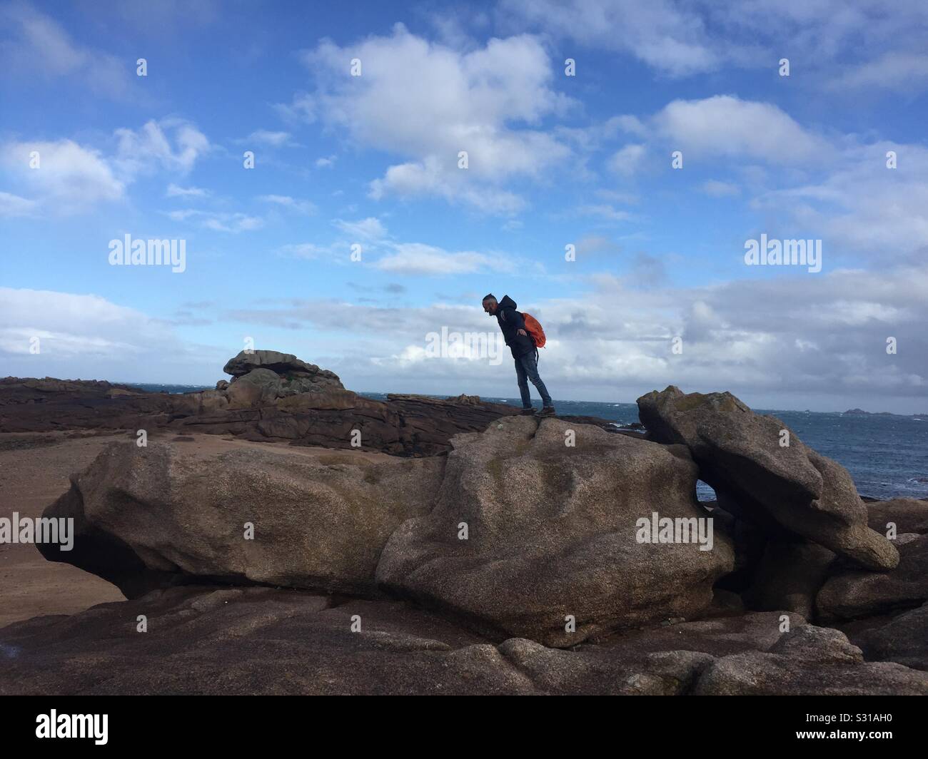 Man standing on rocks by ocean hi-res stock photography and images - Alamy