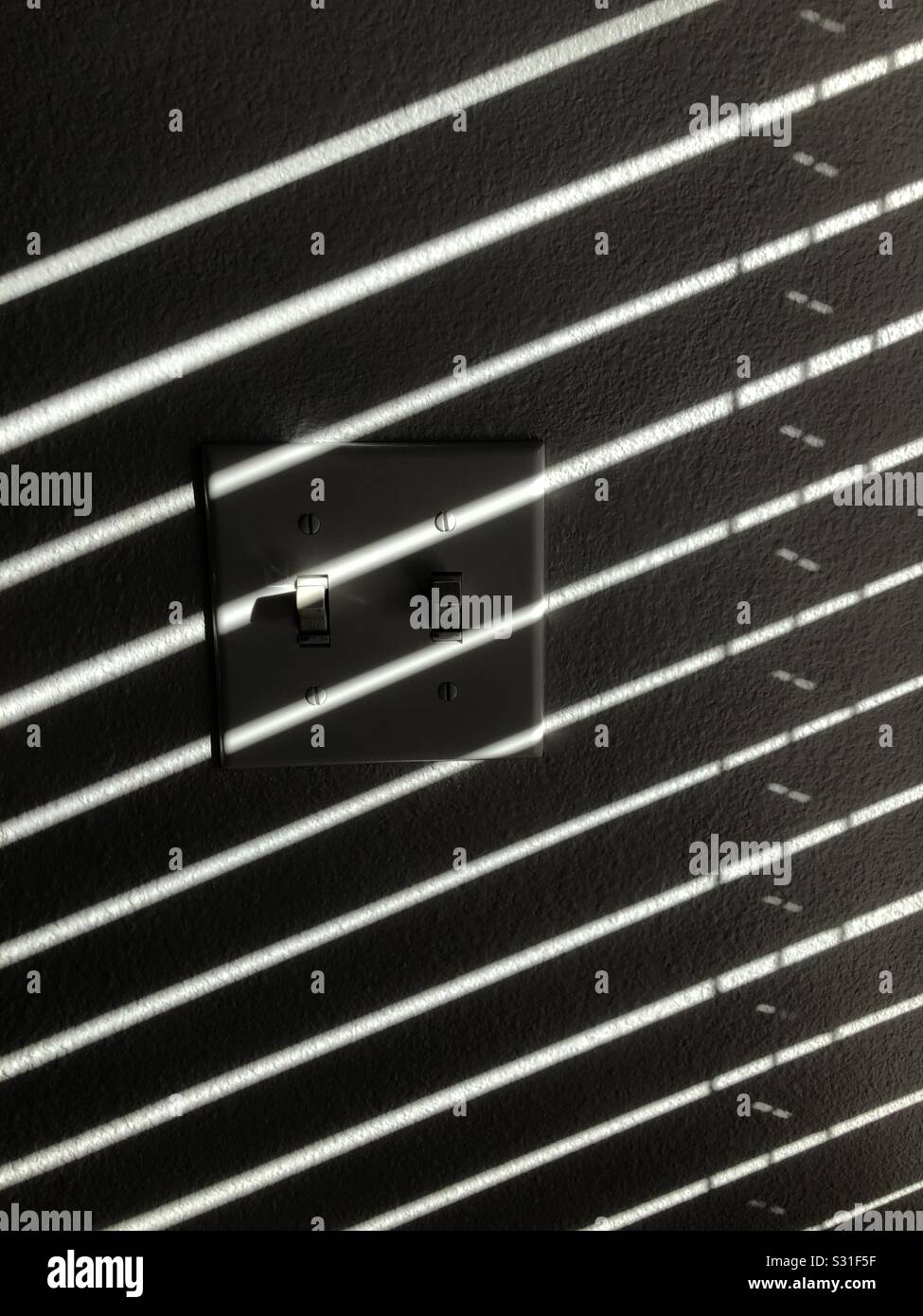 Light cast upon a light switch through window blinds Stock Photo - Alamy
