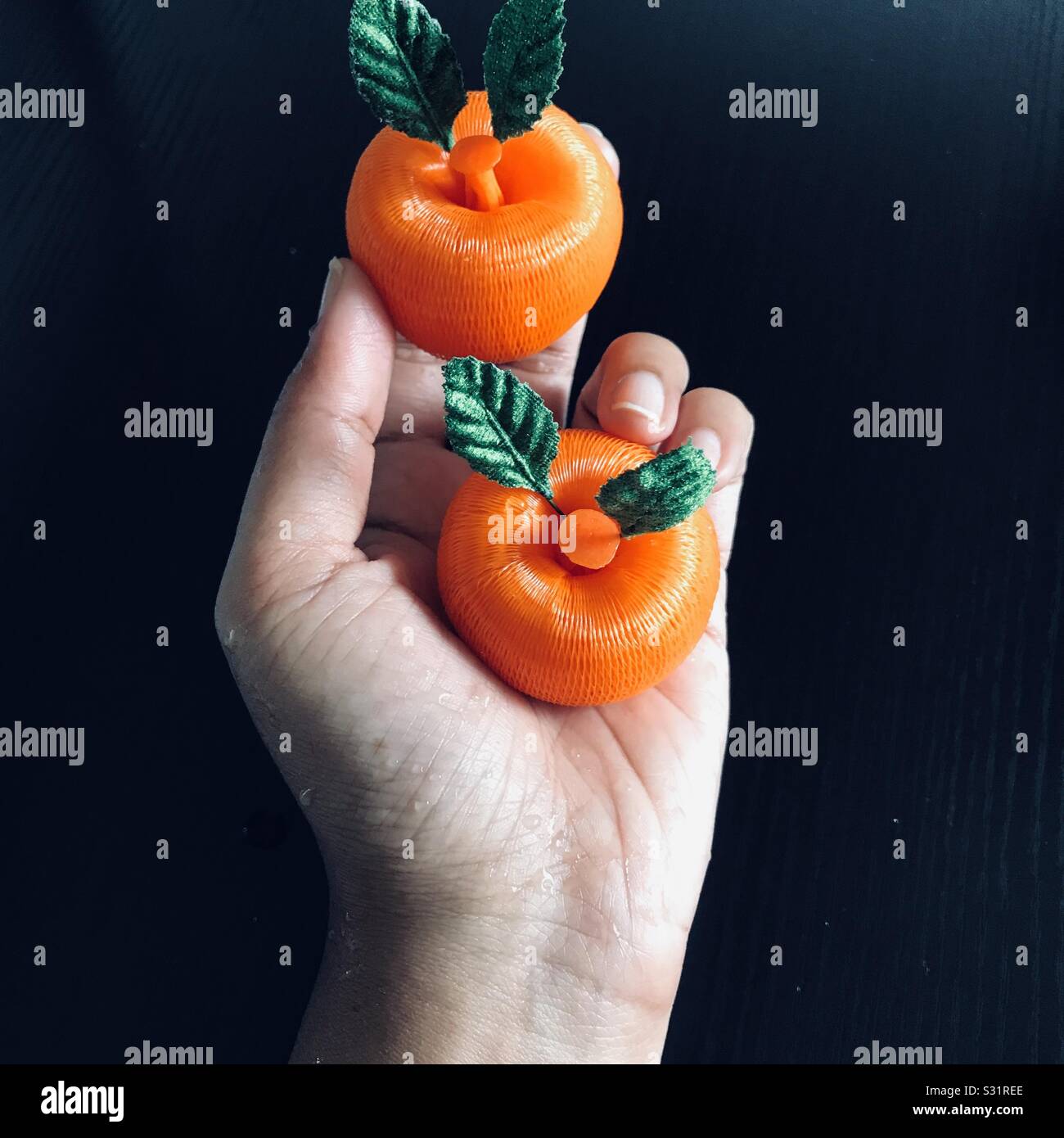 Handmade two mandarin oranges holding in a palm, Symbol of Chinese New ...