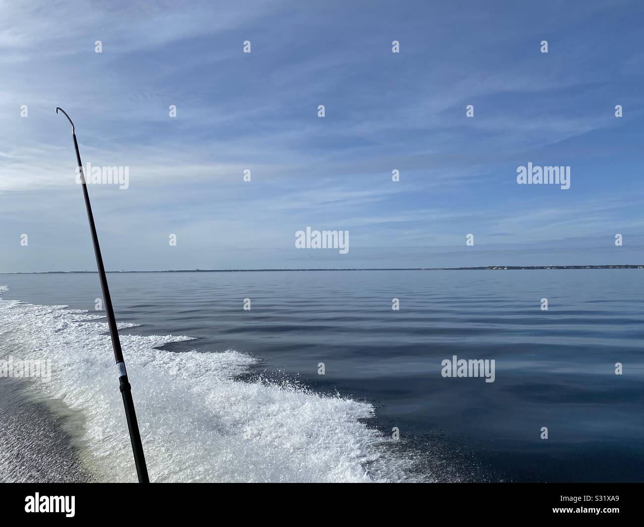 Large fishing hook on boat with wake water and view of Gulf of Mexico ...