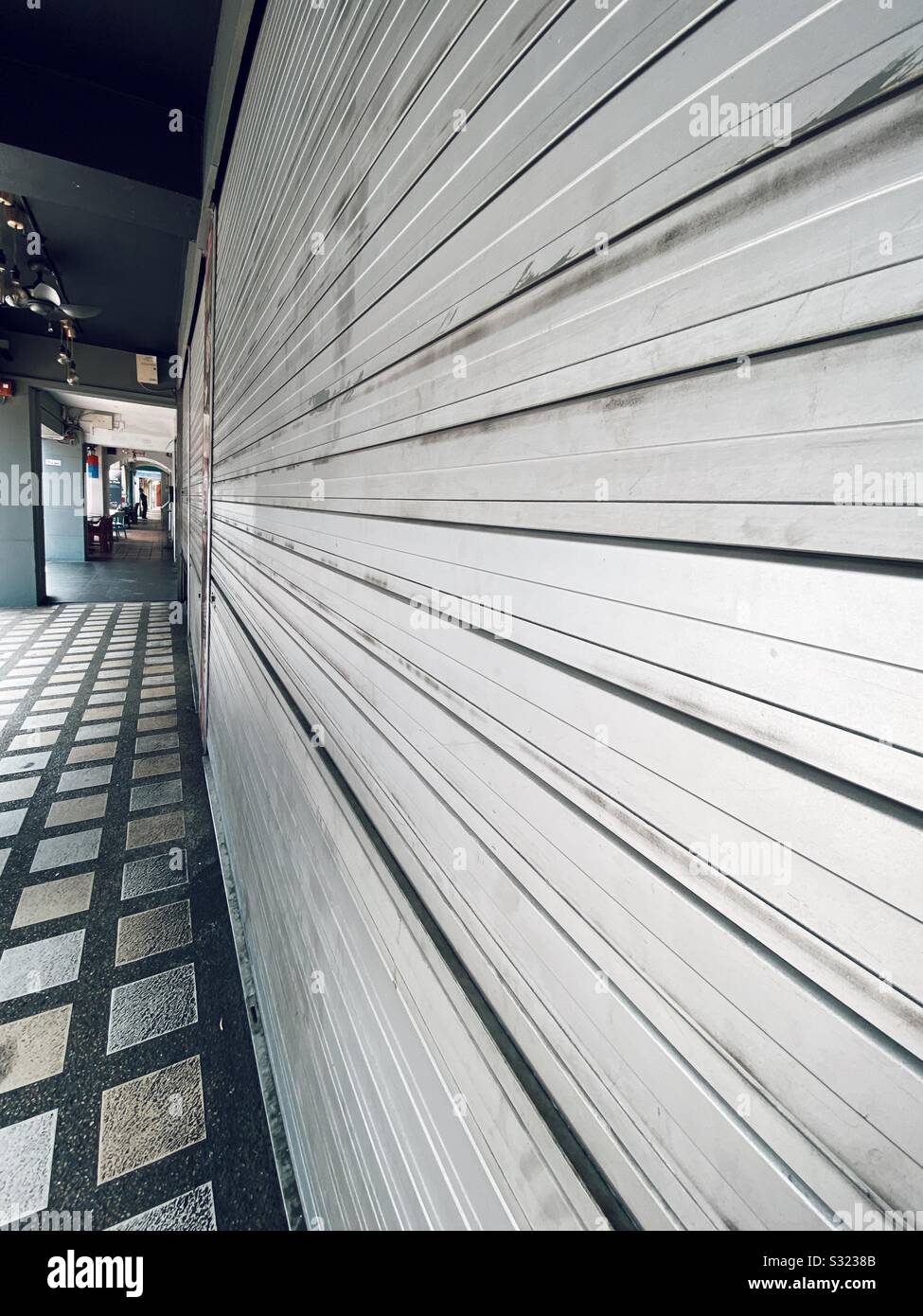 Steel roll down shop front and walkway Stock Photo - Alamy