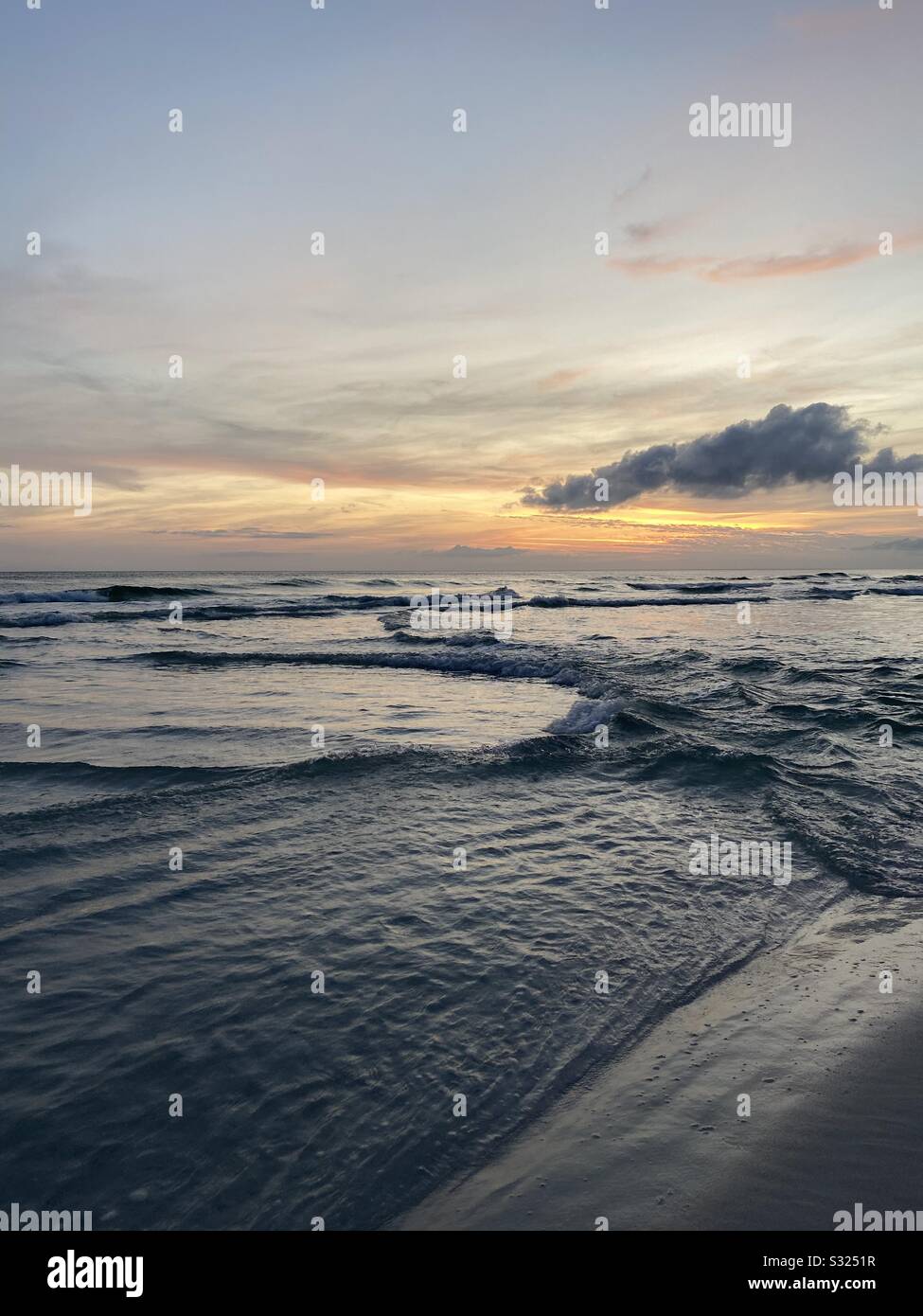 Sunset on the beach with rolling wave water Stock Photo - Alamy