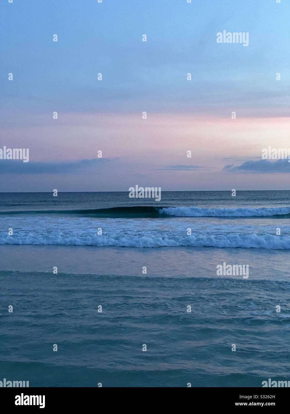 Soft pastel sunset skies on the beach with water and waves Stock Photo ...