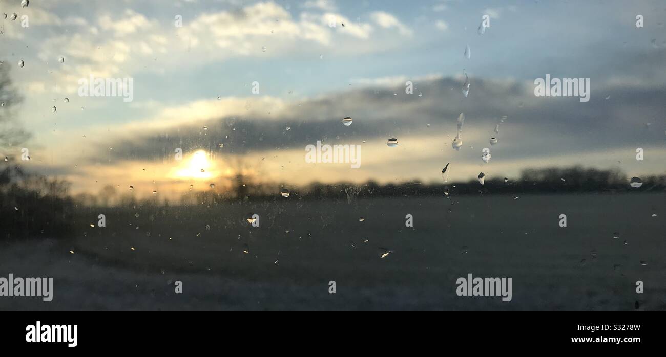 Sunrise through a car window with droplets on the outside Stock Photo ...