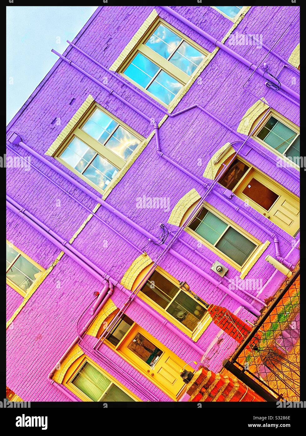 Purple apartment building in small town Stock Photo - Alamy
