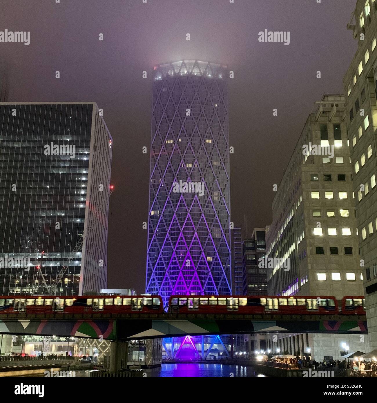 Canary Wharf lights with water and train at night Stock Photo - Alamy