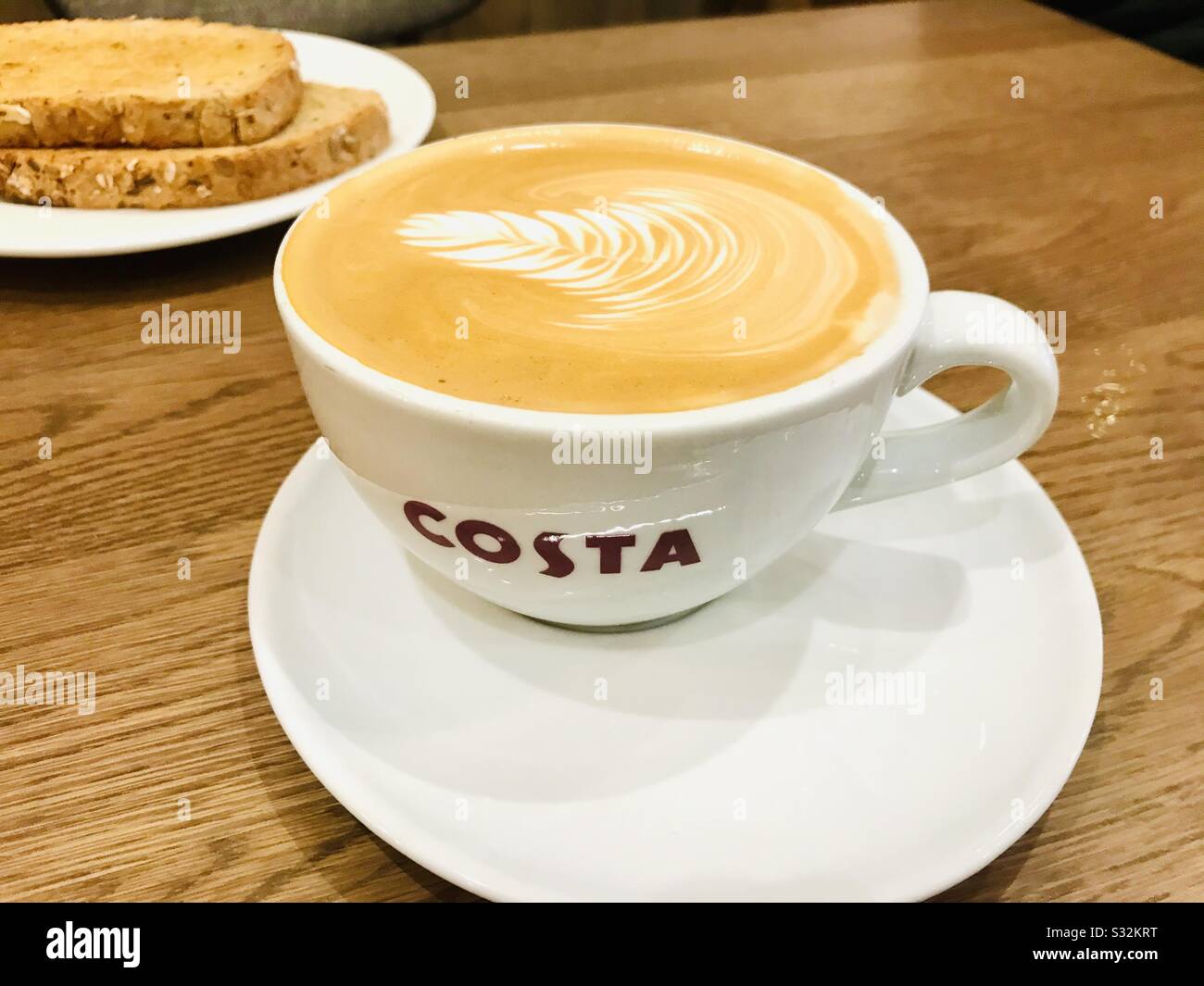 Costa flat white coffee with brown toast in the background Stock Photo ...
