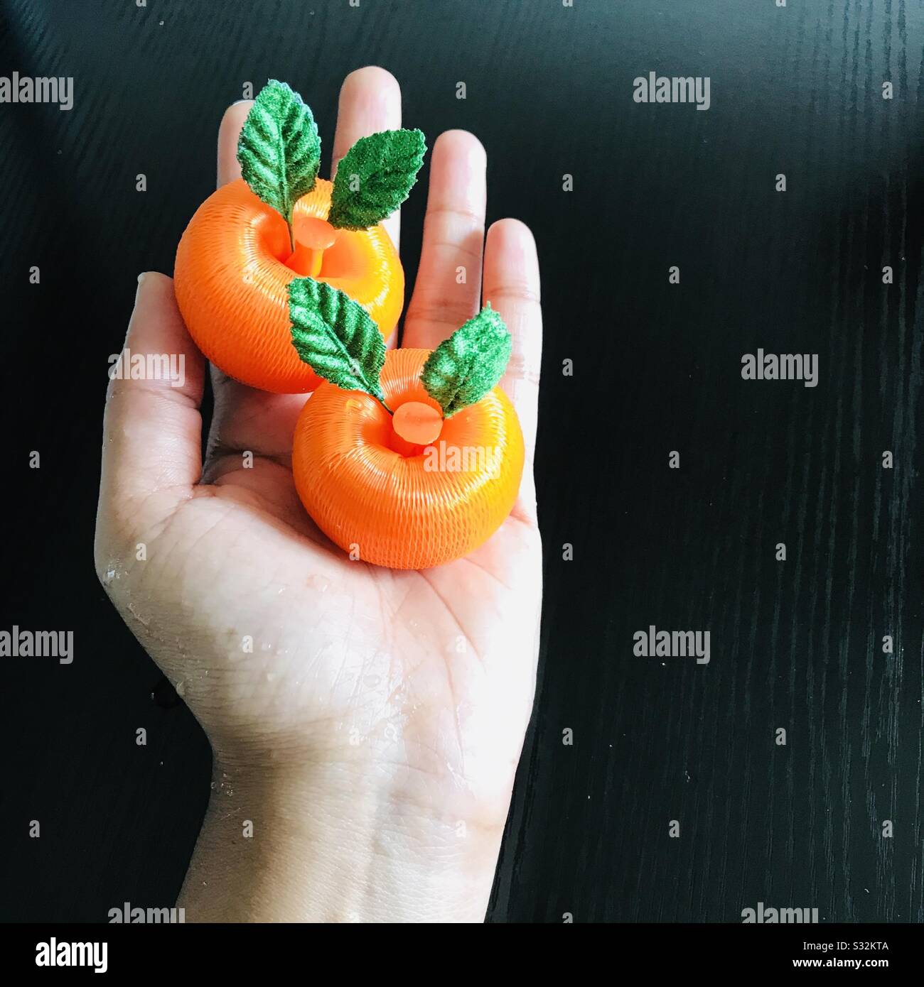 Handmade two mandarin oranges holding in a palm, Symbol of Chinese New ...
