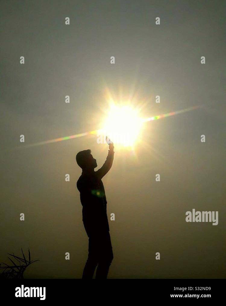 Man holding the sun with an empowering photo to show strength ...