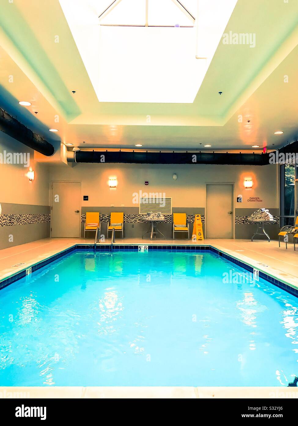 Indoor swimming pool with overhead lighting Stock Photo - Alamy