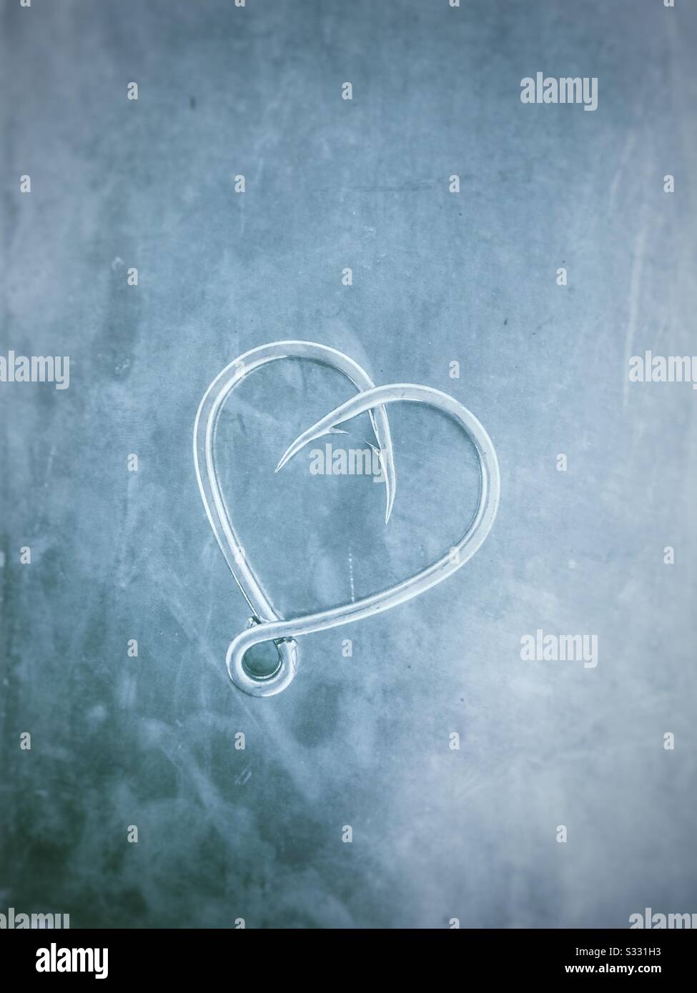 Two fishing hooks placed to look like a love heart Stock Photo - Alamy