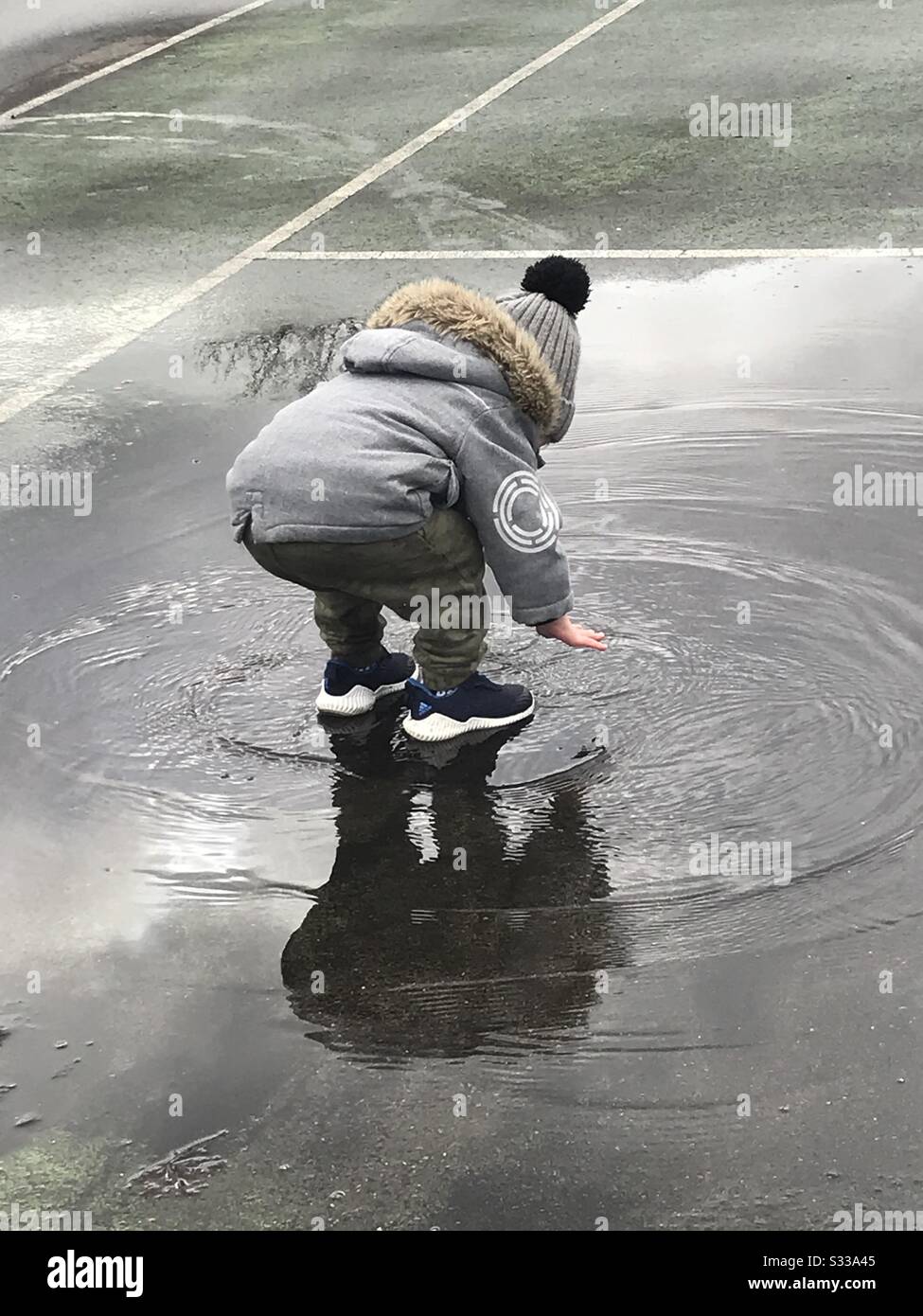 Boy jumping in muddy puddles Stock Photo - Alamy