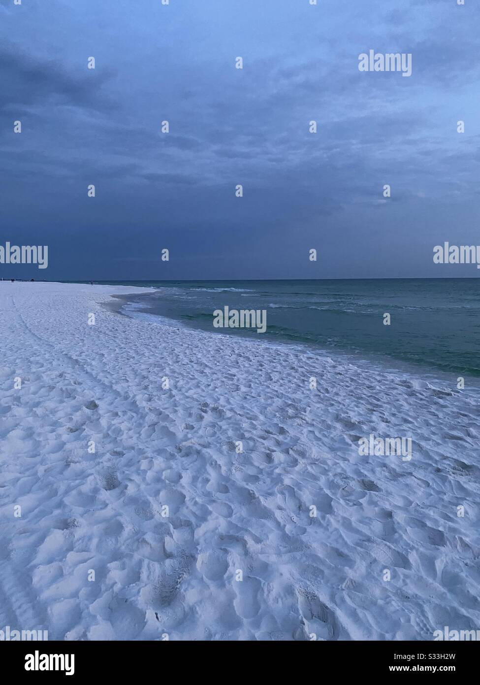 Evening skies during the blue hour on white sand beach Stock Photo - Alamy