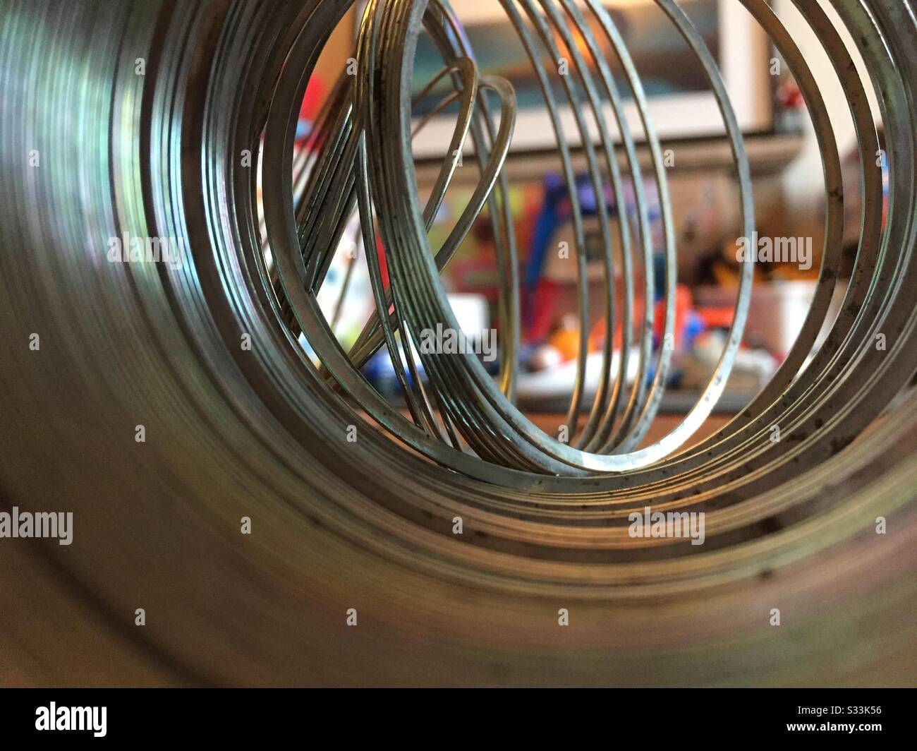 Tangled silver slinky Stock Photo - Alamy