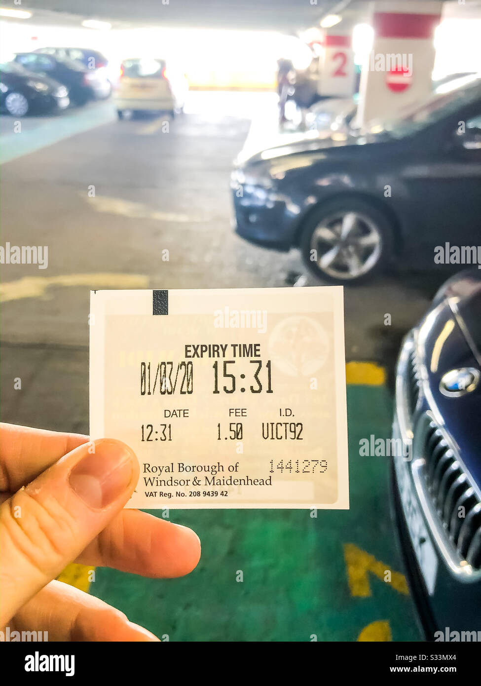 A hand holding a pay and display parking ticket in a car park Stock ...