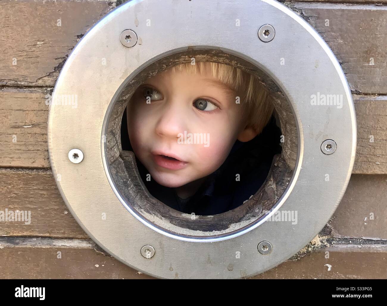 A child playfully peaks through a hole Stock Photo - Alamy