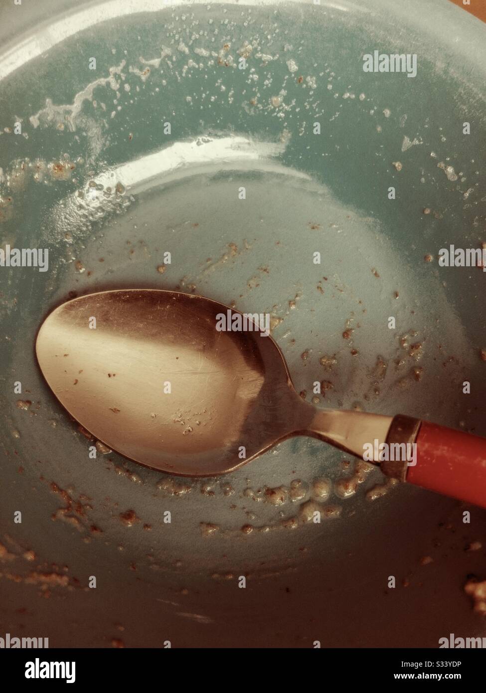 Spoon in an empty, dirty breakfast bowl Stock Photo - Alamy